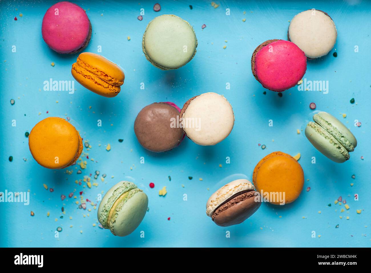 French sweet colorful fruit cookies macaroons with crumbs falling on ...
