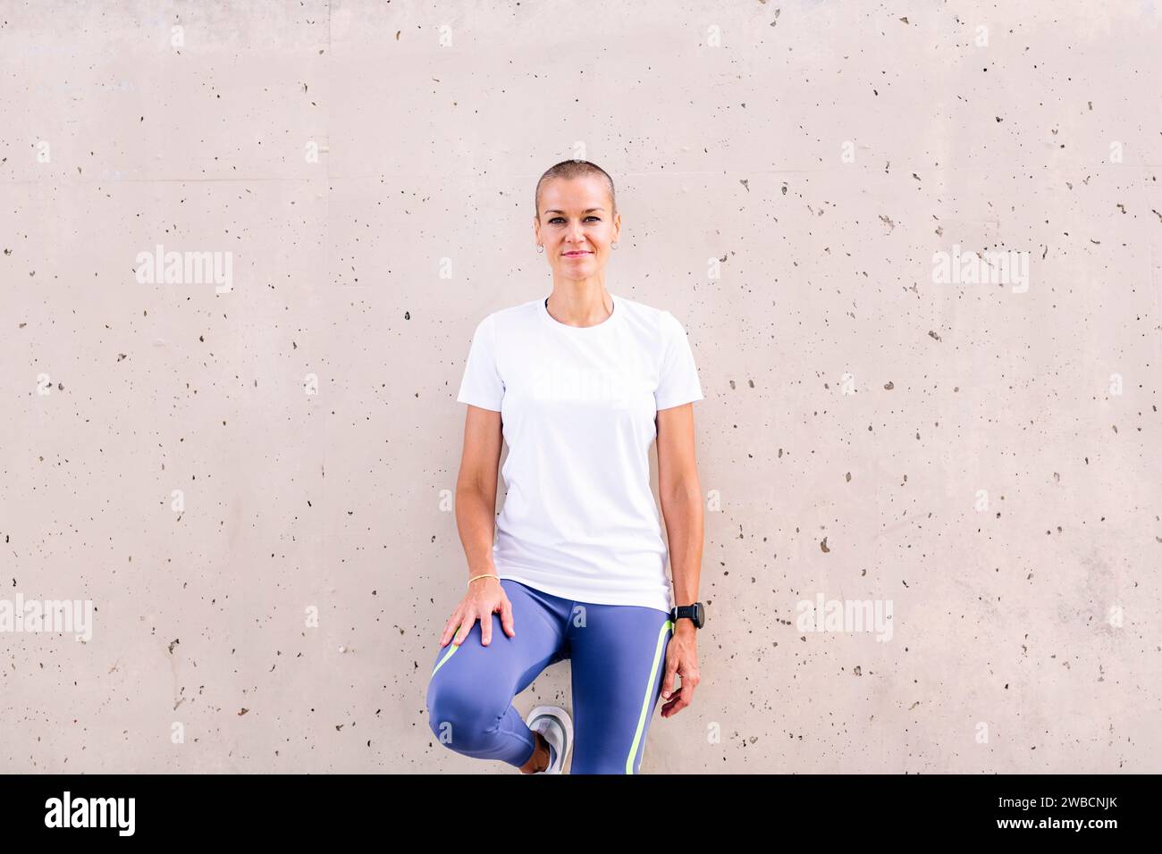 young sports woman smiling happy leaning on a wall Stock Photo - Alamy