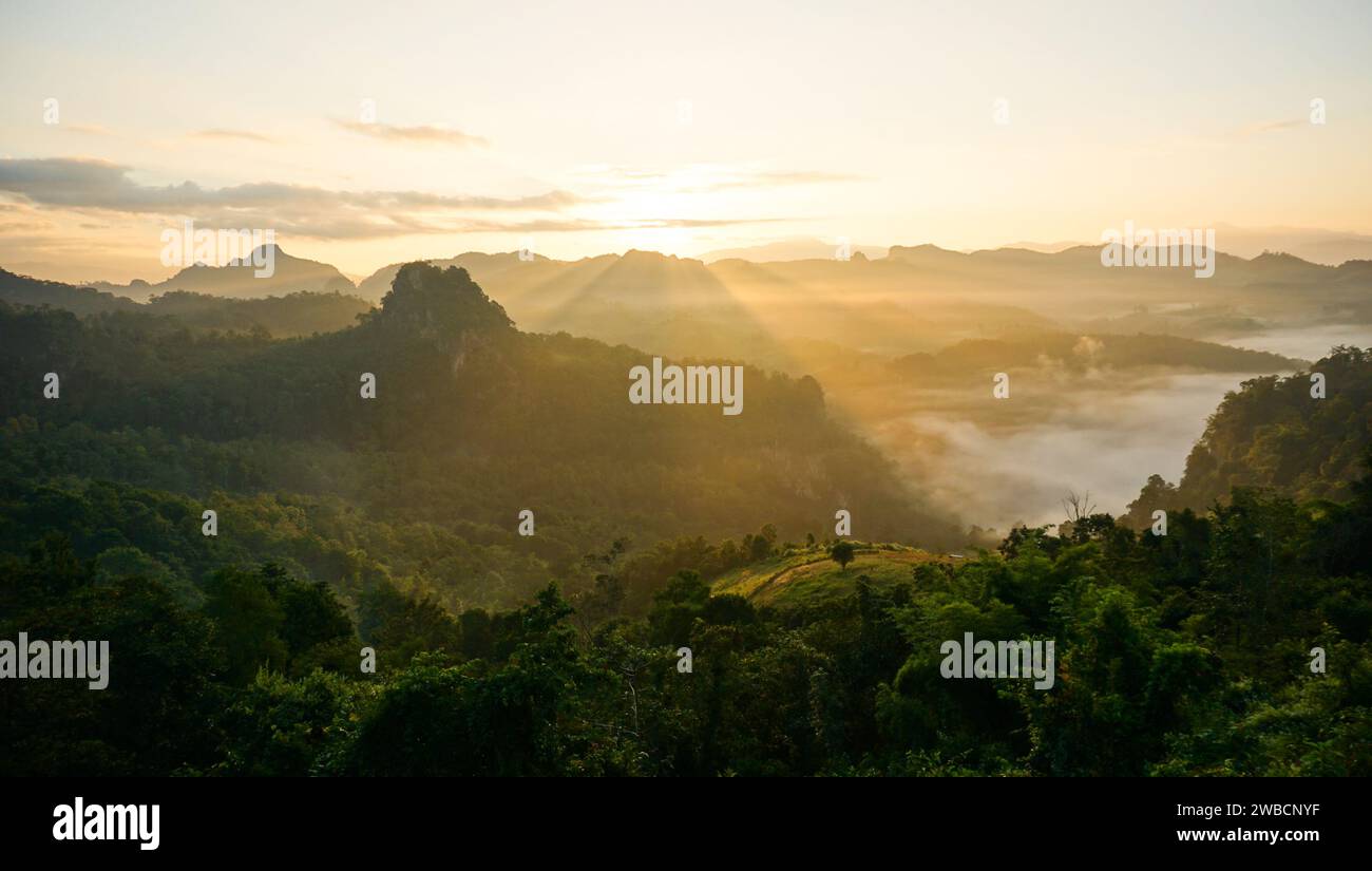 Mountain Top in the clouds over flowing fog between mountain peaks ...