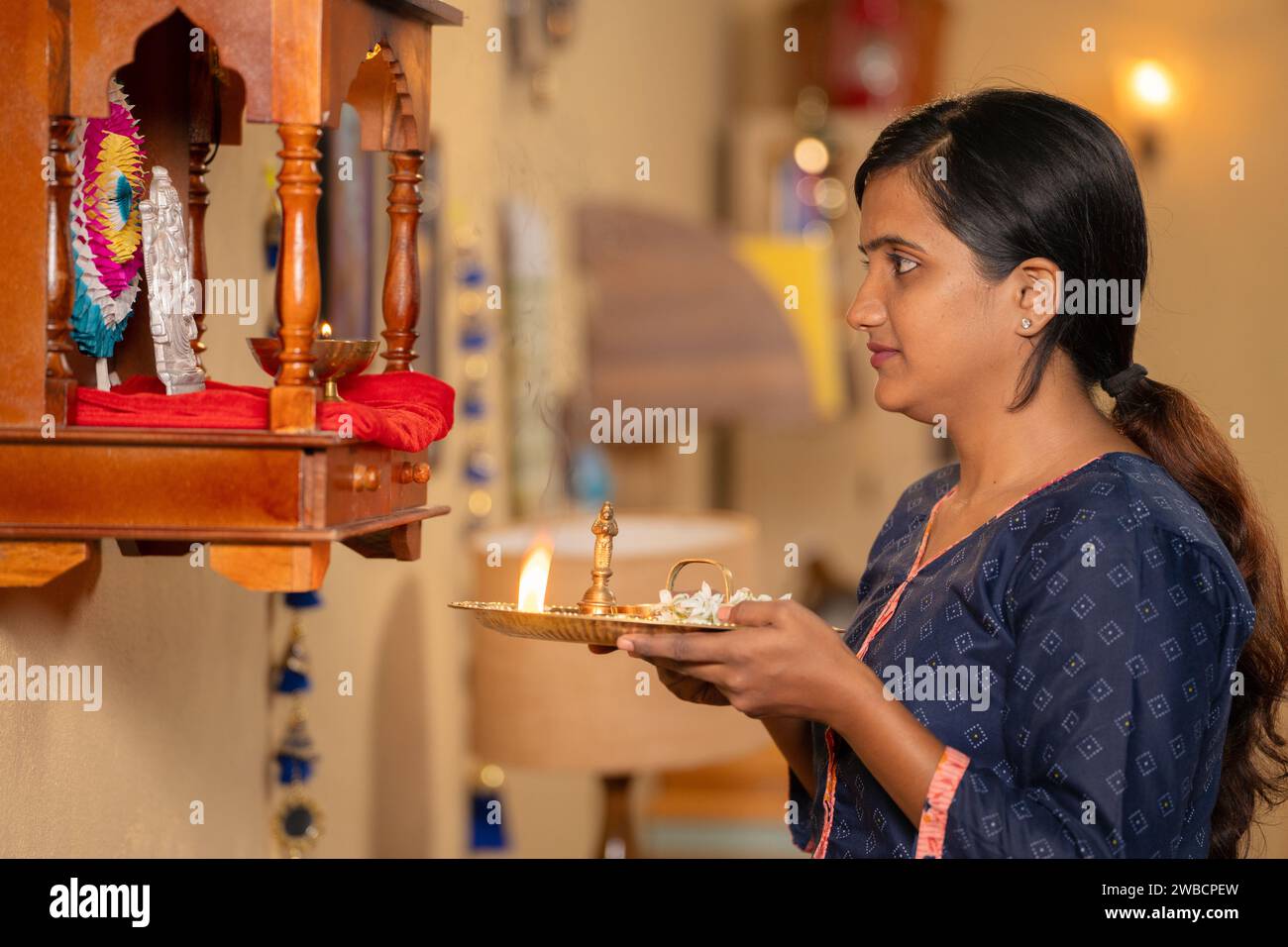 devotional young girl offering aarthi to god in front of mandapan at ...