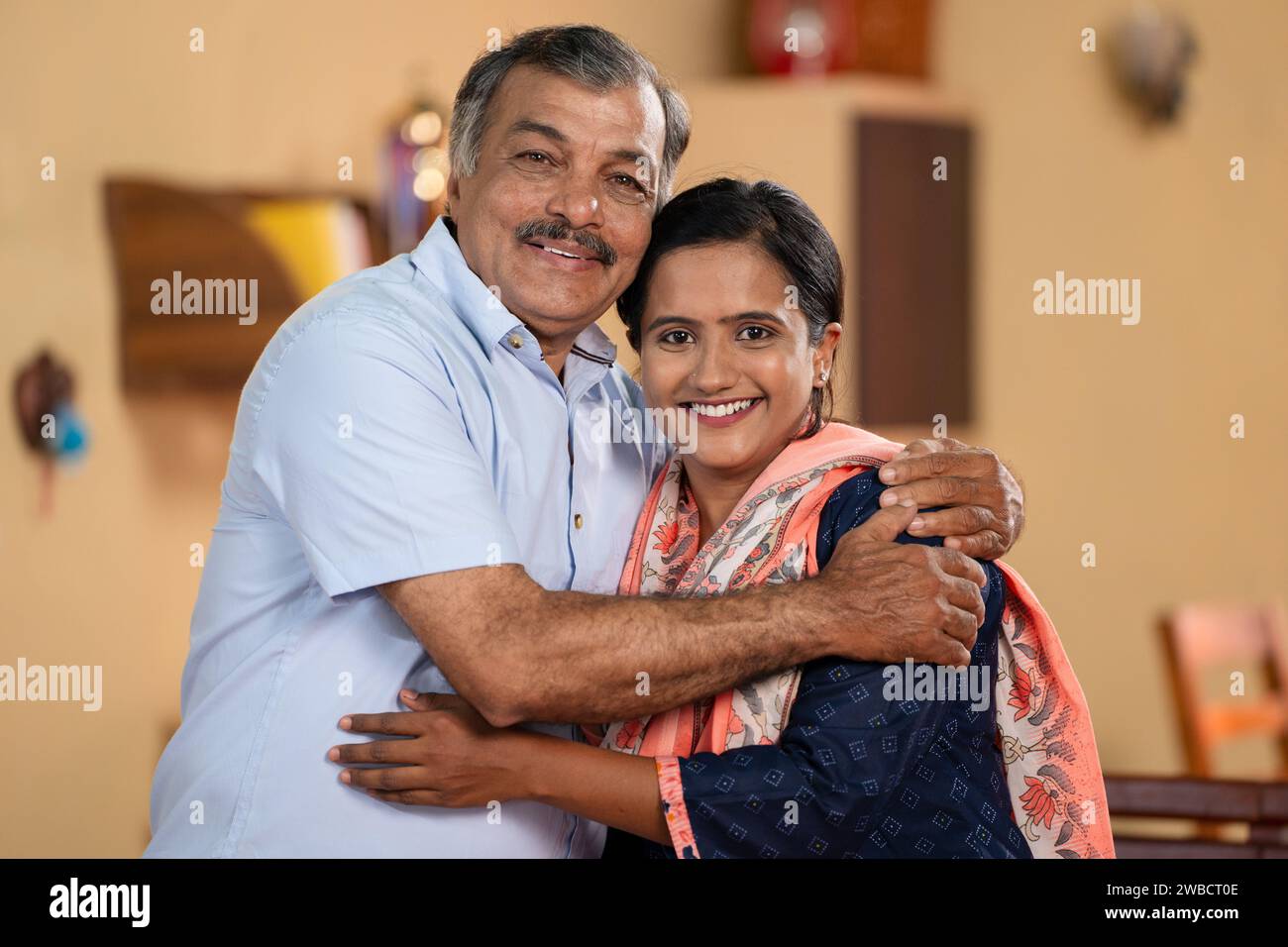 Happy Indian father embracing or hugging teenager daughter at home ...