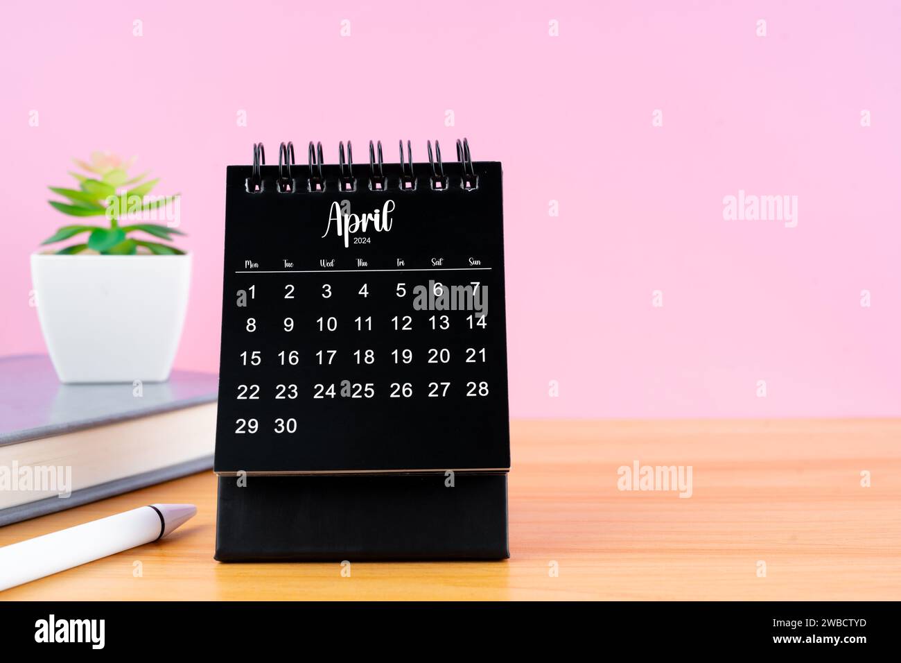 April Mini desk calendar for 2024 year on worktable with pink color ...