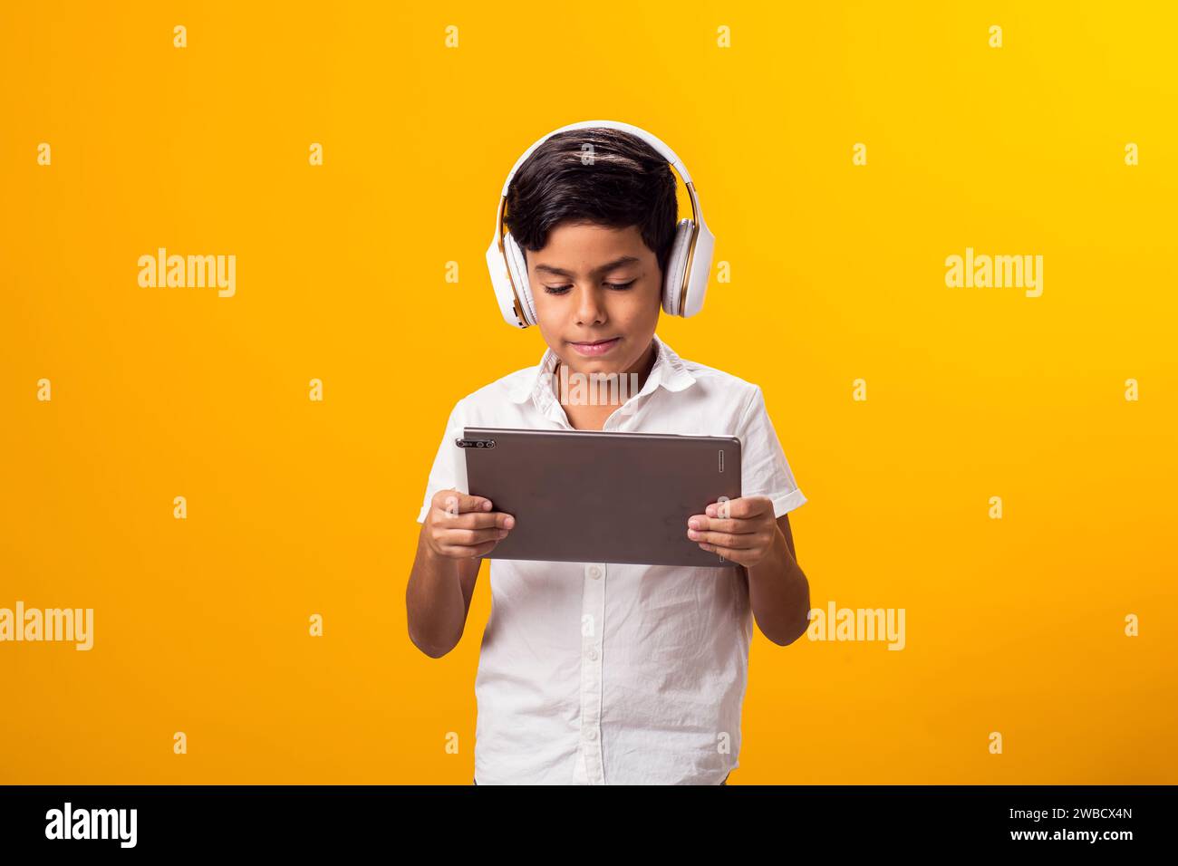 Portrait of kid boy with headphone and tablet playing video game ...