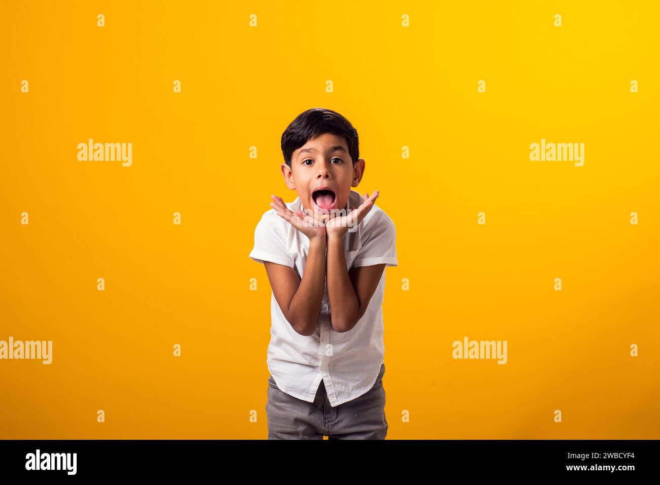 Portrait of surprised kid boy over yellow background. Astonished ...