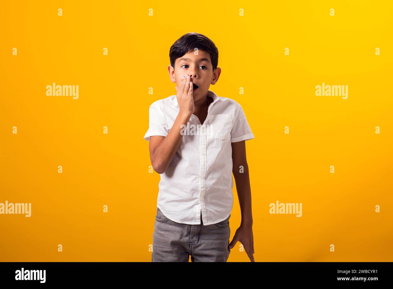 Portrait of surprised kid boy over yellow background. Astonished ...