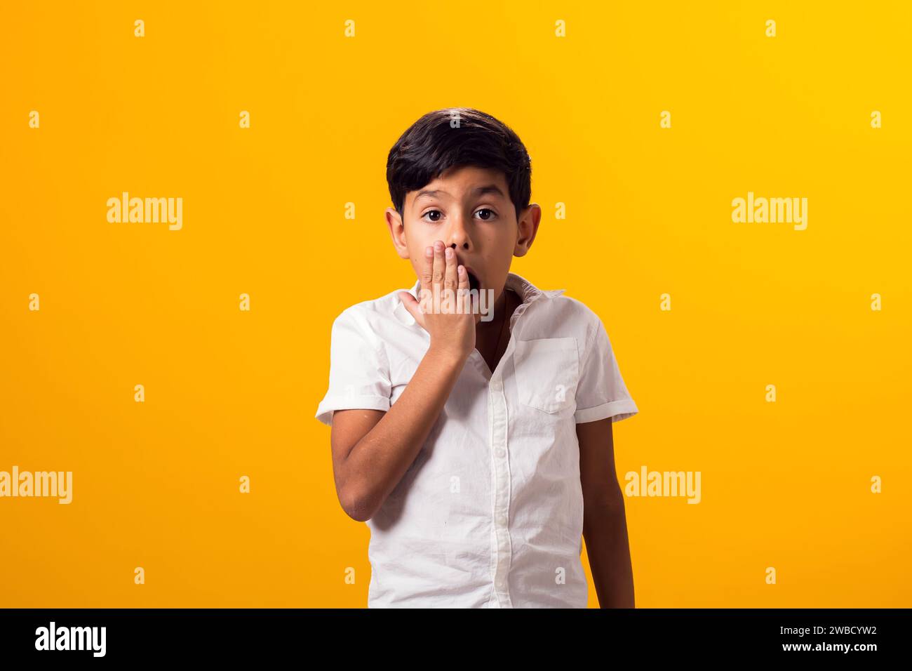 Portrait of surprised kid boy over yellow background. Astonished ...