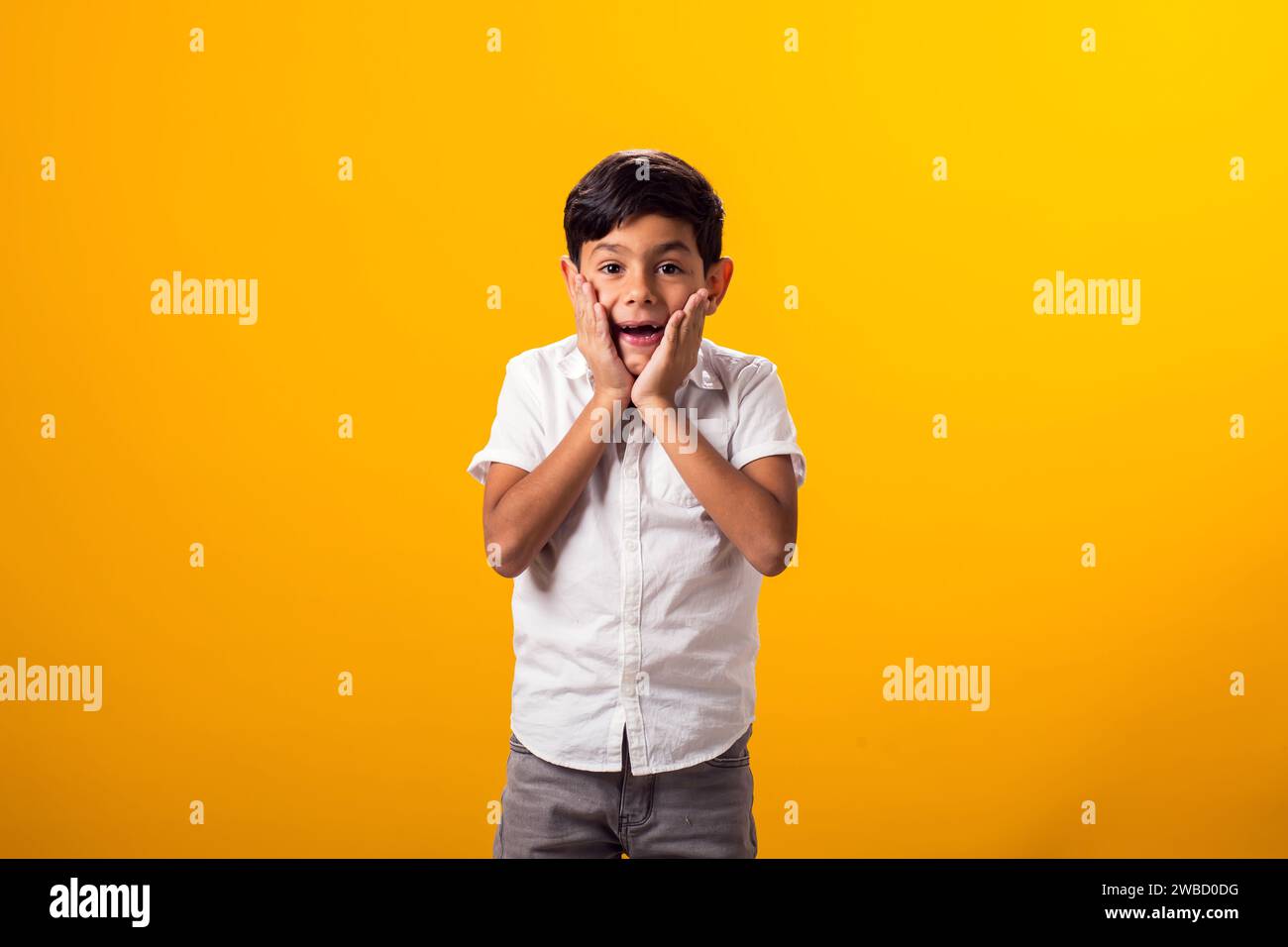 Portrait of surprised kid boy over yellow background. Astonished ...