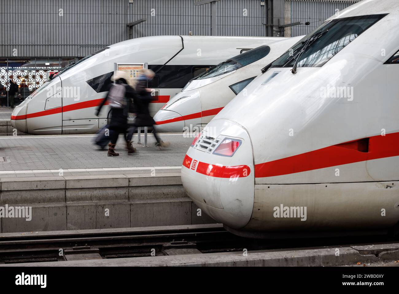 Munich, Germany. 09th Jan, 2024. Travelers walk past parked ICE trains ...