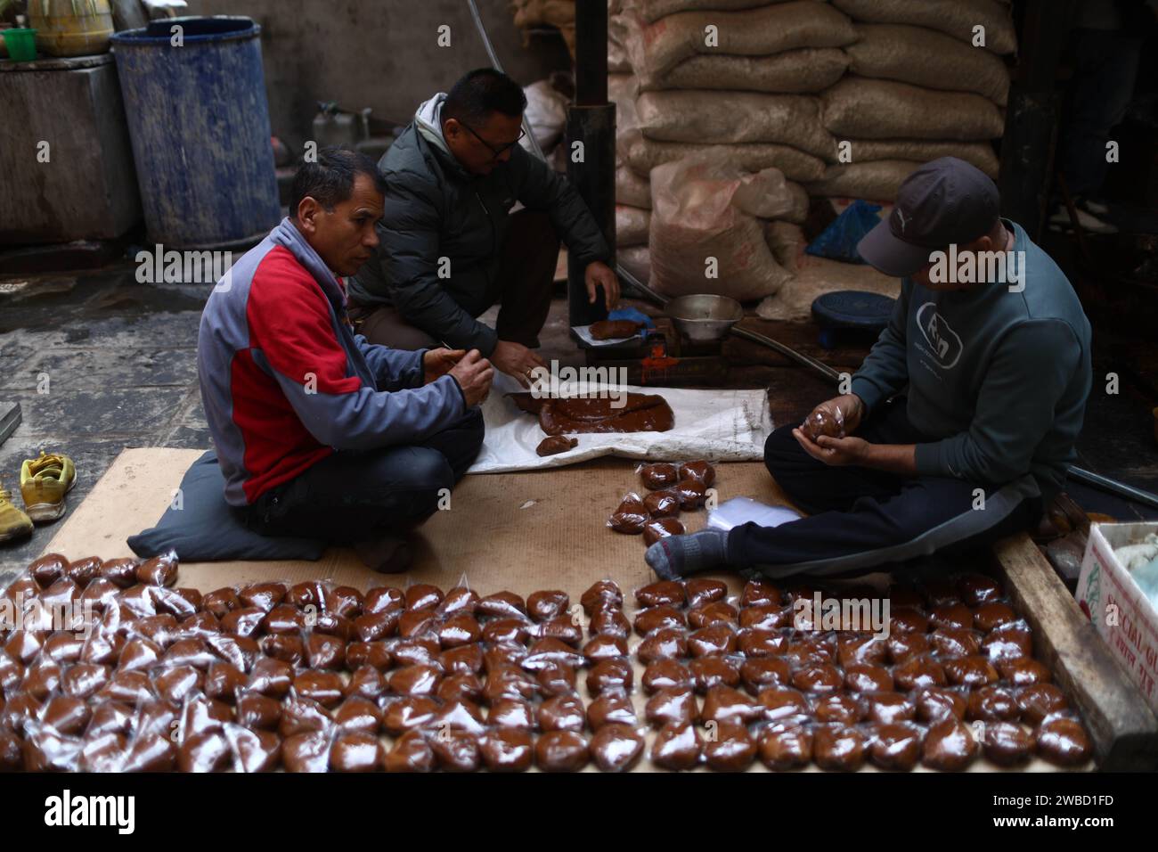 Lalitpur, Nepal. 10th Jan, 2024. People pack Chaku, a Nepalese sweet ...