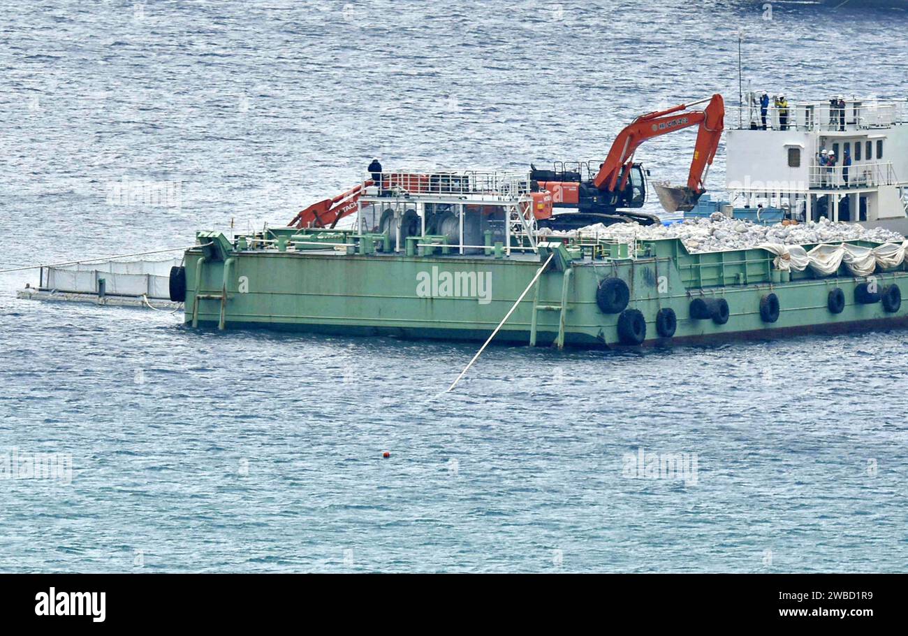 Stones are thrown from a barge ship in Nago City, Okinawa prefecture on ...