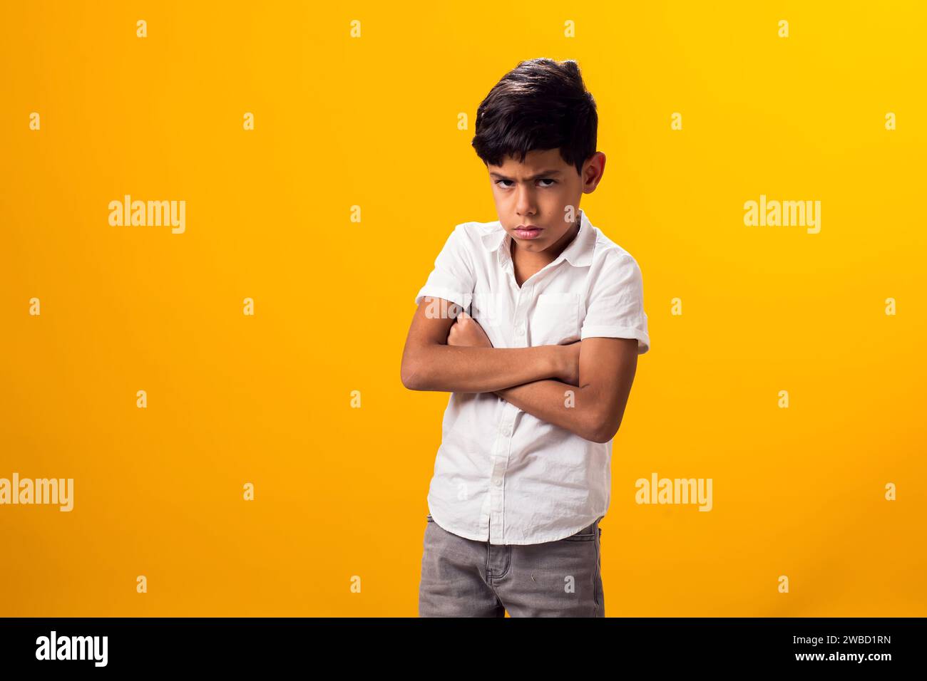 Portrait of upset kid boy over yellow background. Emotions and bulling ...