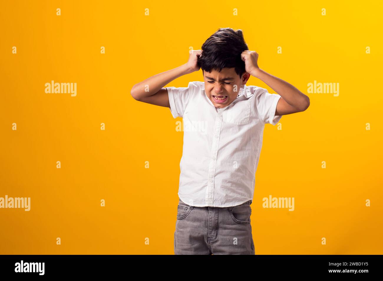 Portrait of angry kid boy over yellow background. Stress and aggression ...