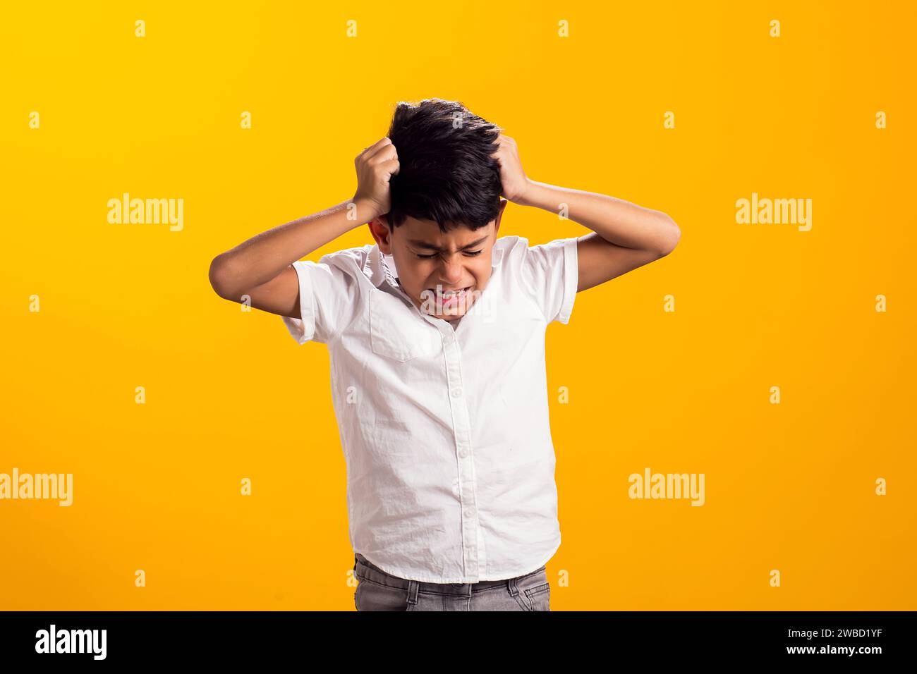 Portrait of angry kid boy over yellow background. Stress and aggression ...