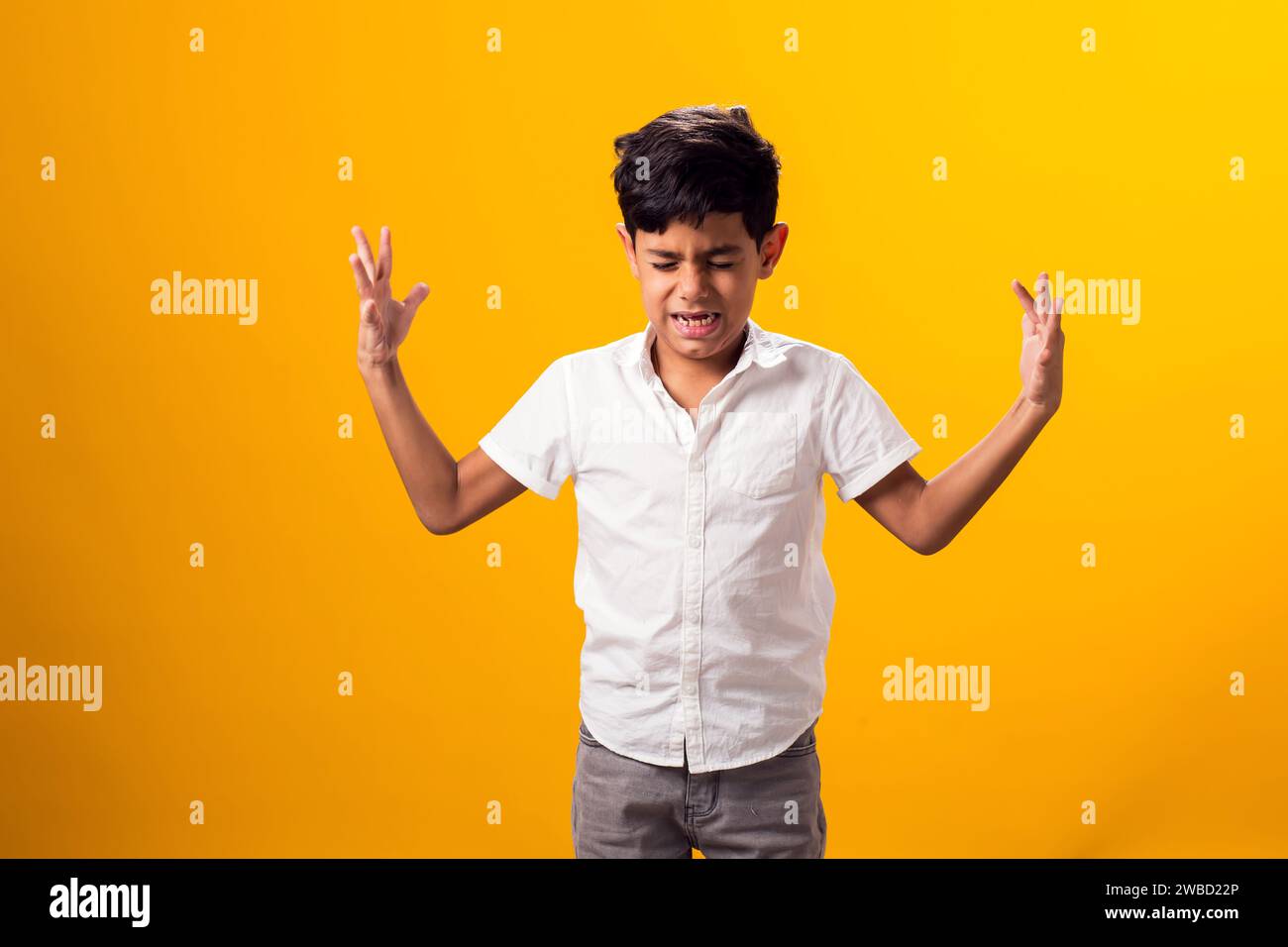 Portrait of angry kid boy over yellow background. Stress and aggression ...