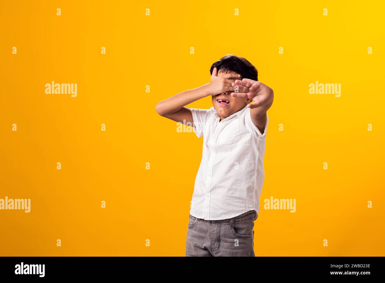 Portrait of scared kid boy showing stop gesure and covering eyes over ...