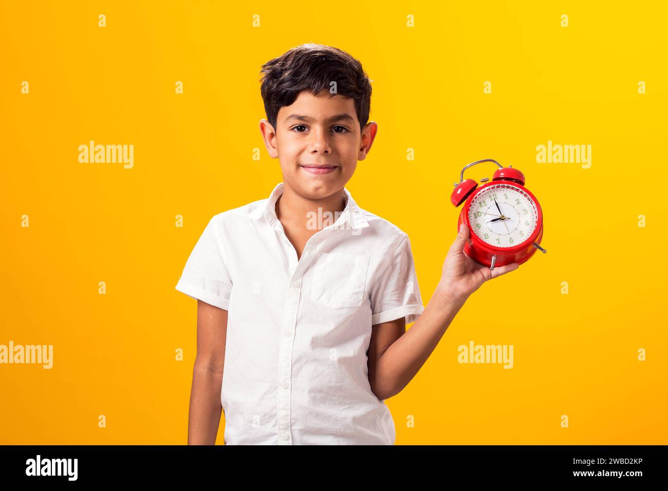 Portrait of kid boy holding alarm clock. Education and time management ...
