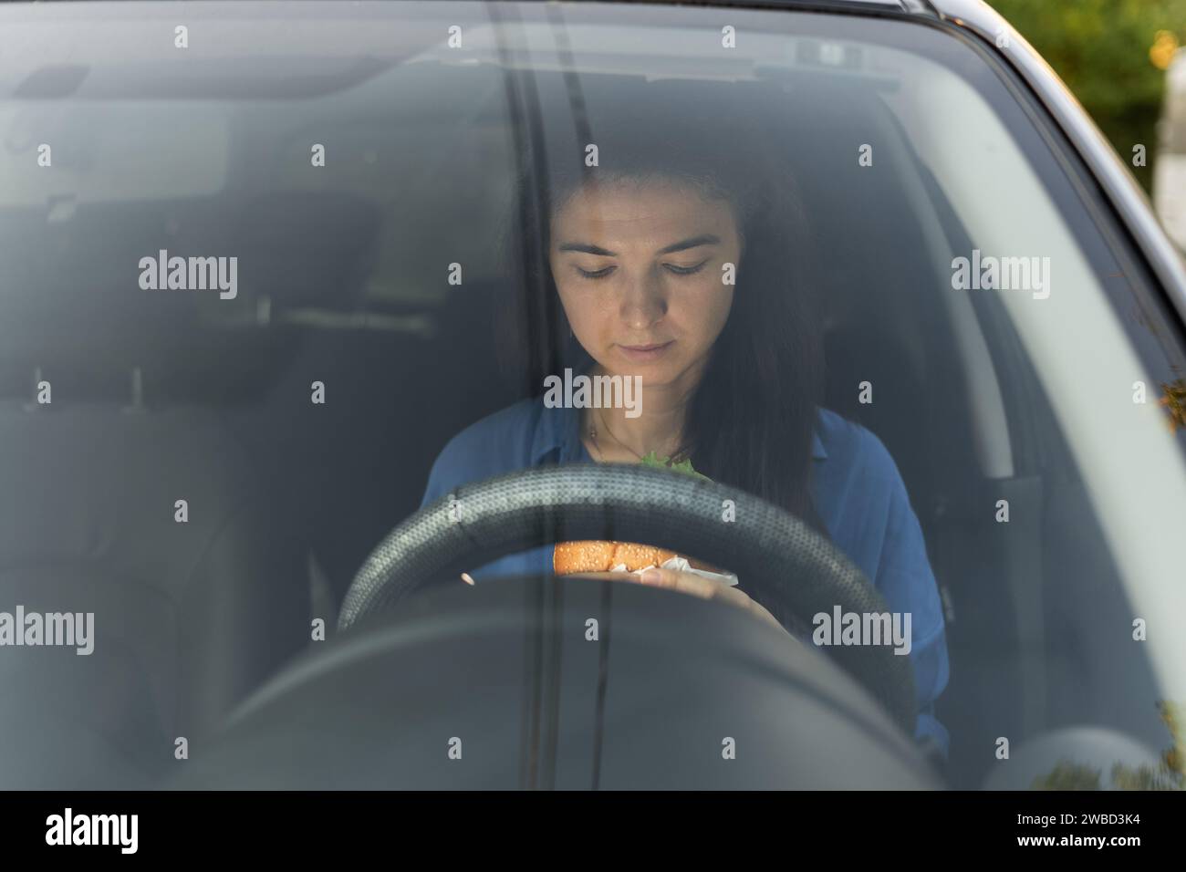 Woman eating in car, people eating burger in vehicle in traffic jam ...