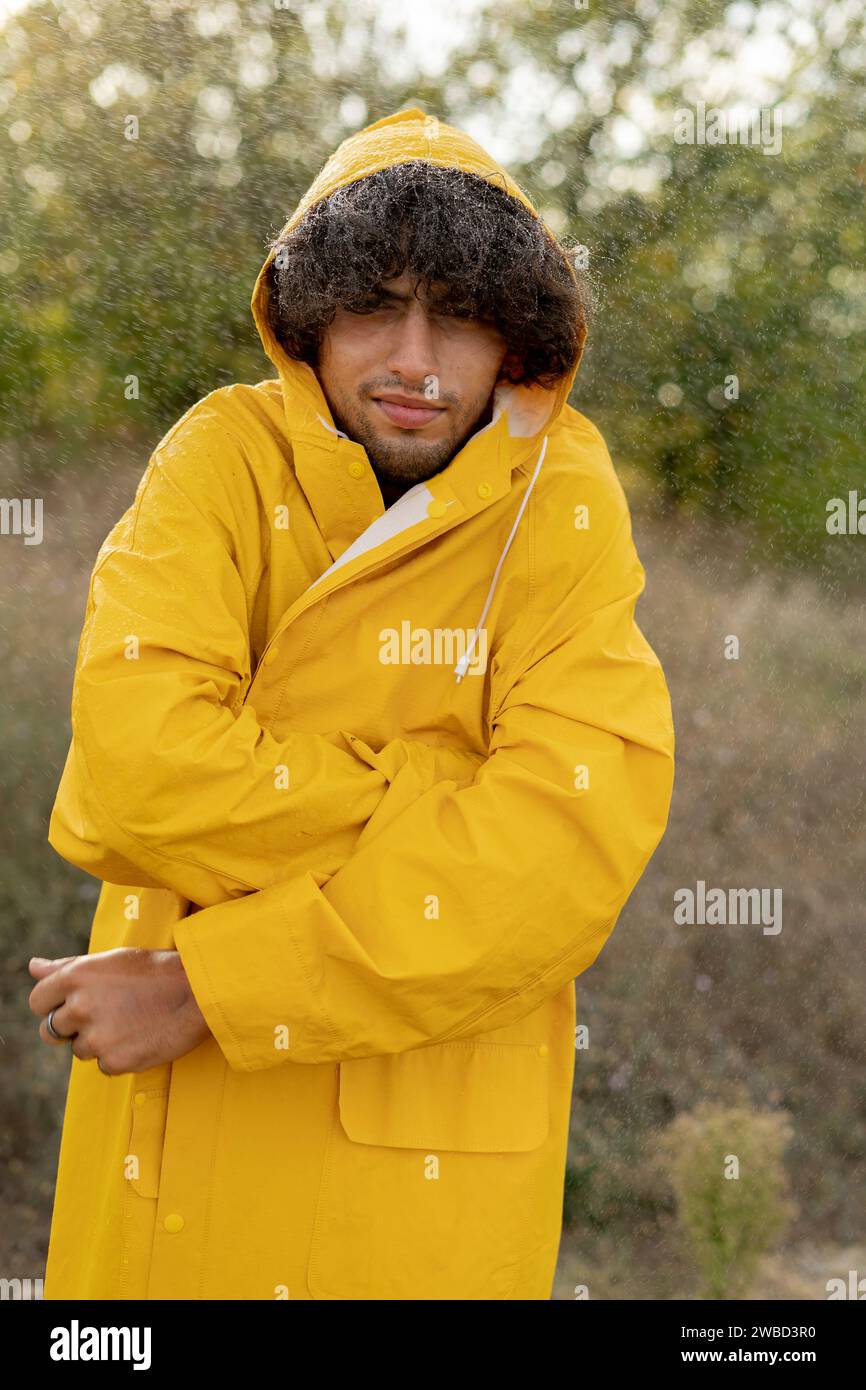 Portrait of an Arab man in a yellow raincoat freezing in the autumn ...