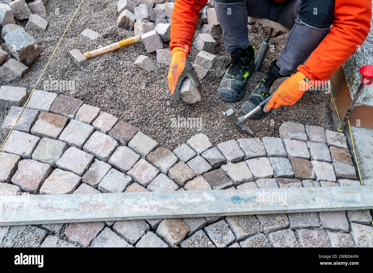 Resurfacing the road surface, manual laying of porphyry cubes on the ...