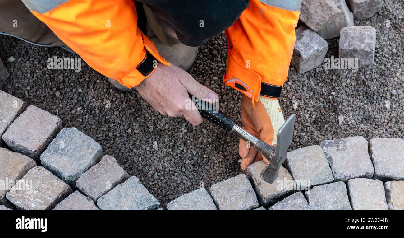 Resurfacing the road surface, manual laying of porphyry cubes on the ...