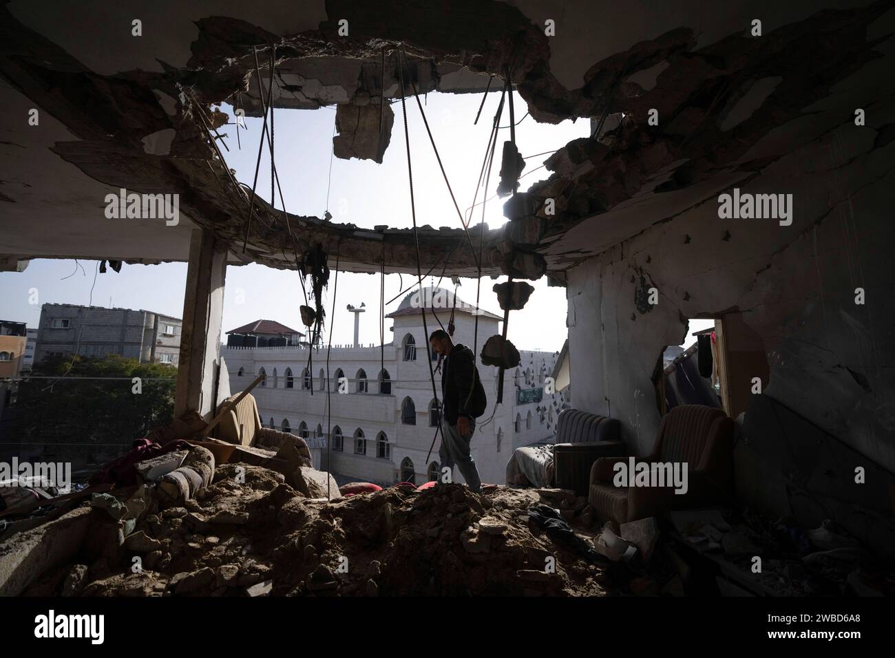 Palestinians look at a damaged residential building after an Israeli ...