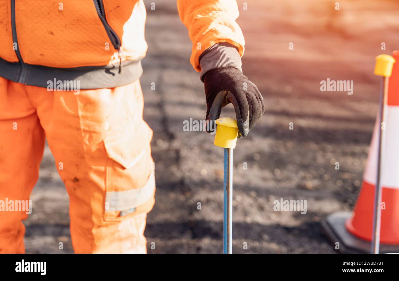 Builder placing yellow plastic safety protecting caps on top of road ...