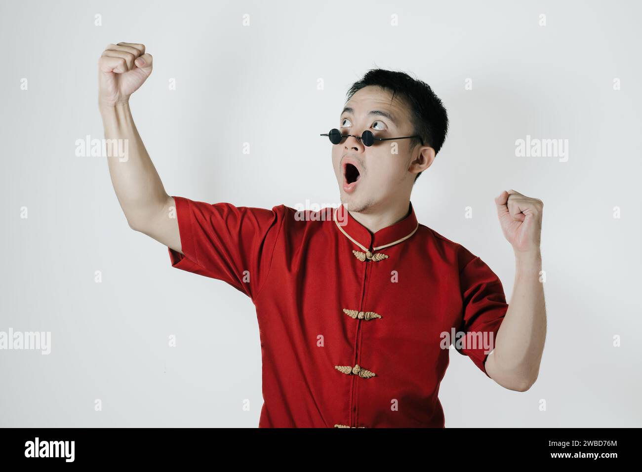 Asian man wearing traditional costume with excited gesture and face ...