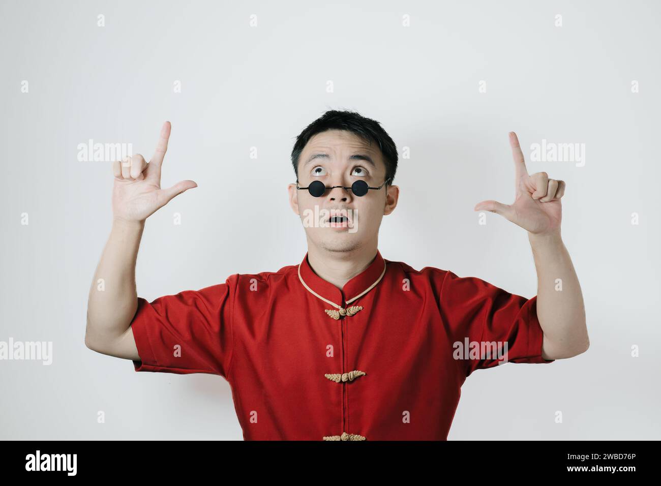 Asian man wearing traditional costume is pointing up on white ...