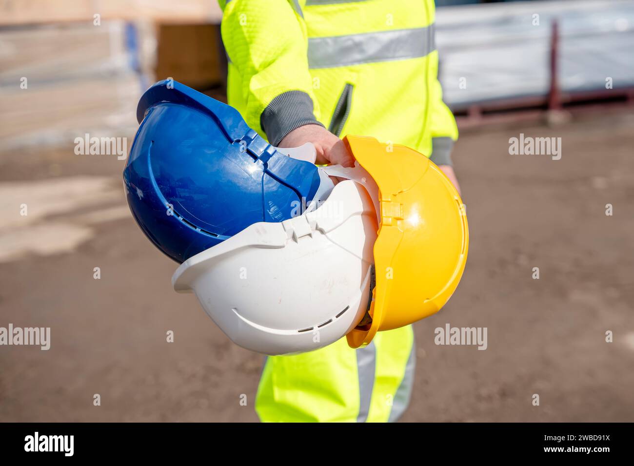 A builder wearing a hi-viz reflective suit gives a choice of helmets ...