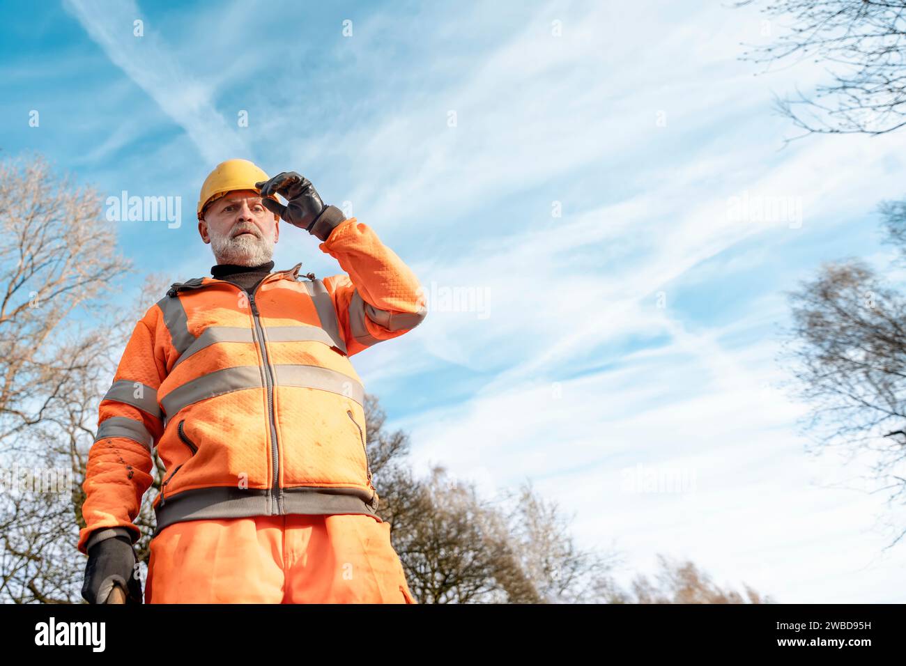 Builder knocking down road setting out steel pins with lump hammer ...