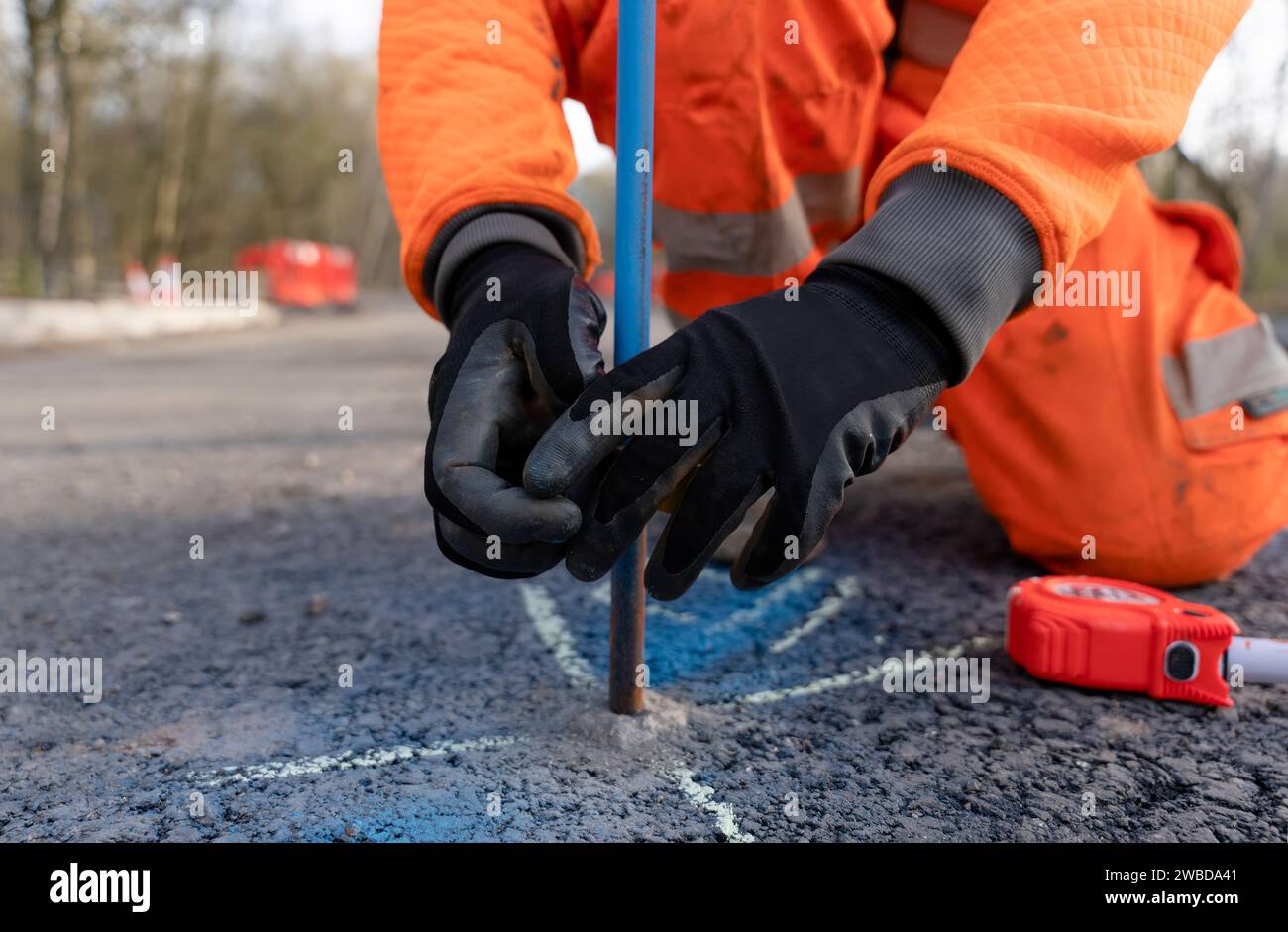 Builder marking future finish road levels on a road setting out steel ...