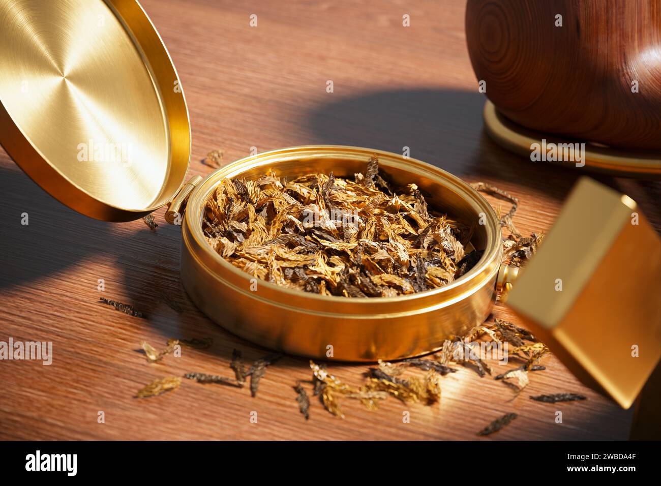 Close-up of an opulent gold tobacco tin, its lid ajar, showcasing ...
