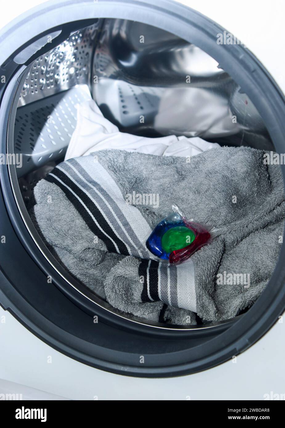 A colorful eco washing gel in capsule in a washing machine with laundry ...