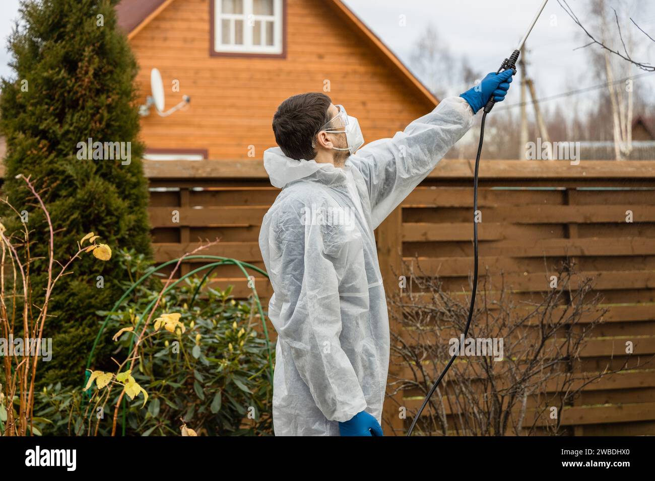 Using chemicals in the garden orchard gardener applying an insecticide ...