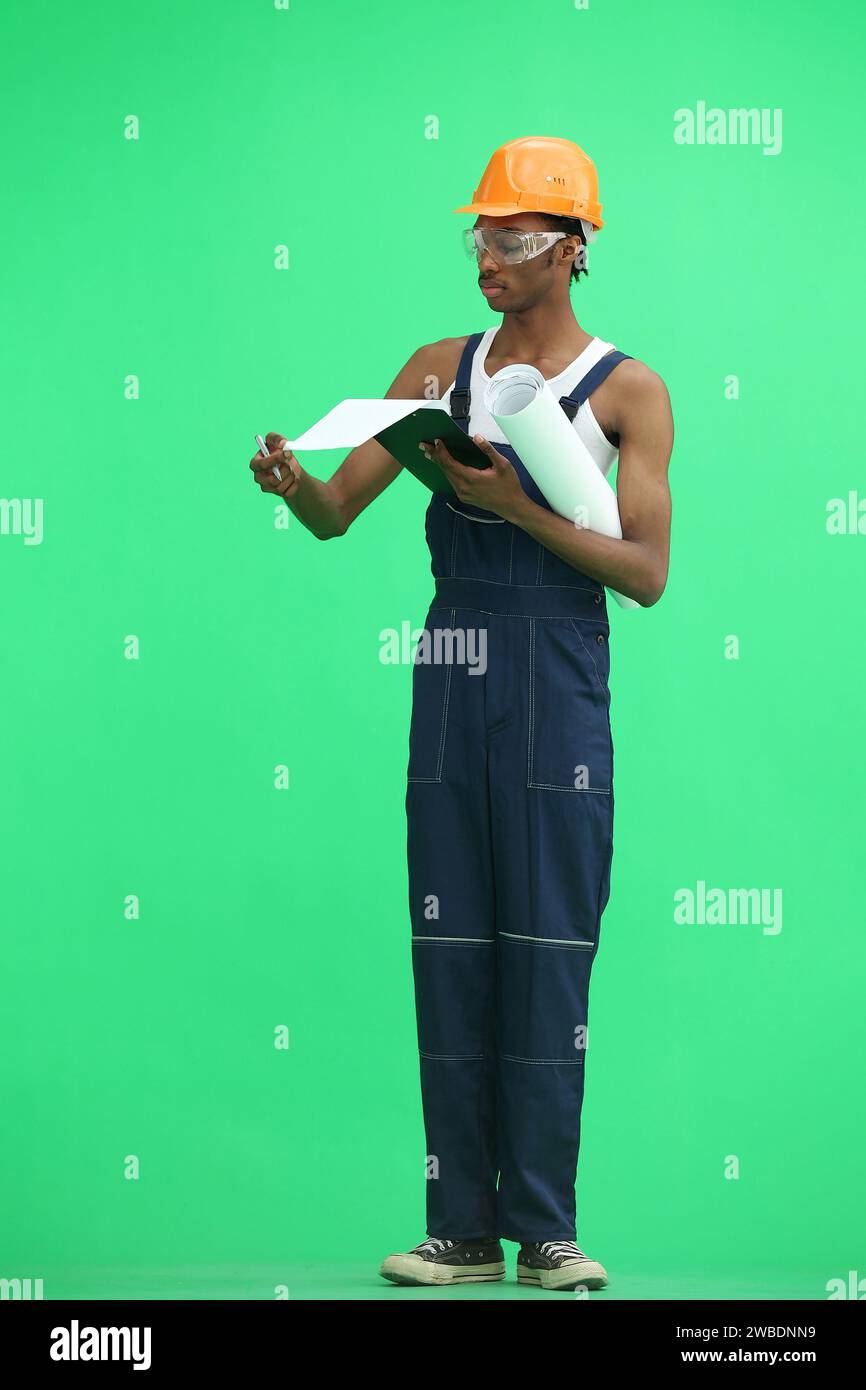 A male builder, on a green background, full-length, with drawings Stock ...