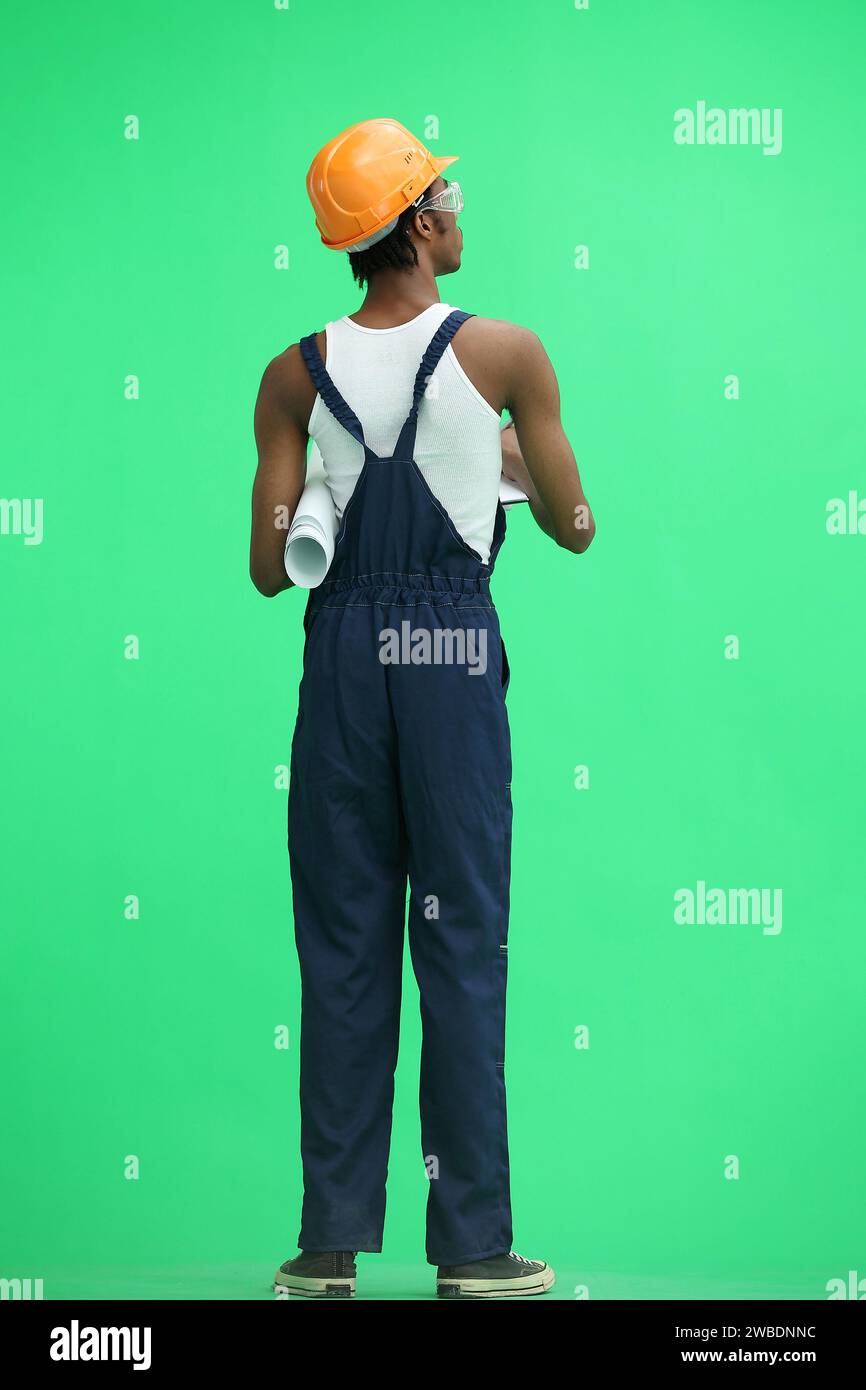 A male builder, on a green background, full-length, with drawings Stock ...