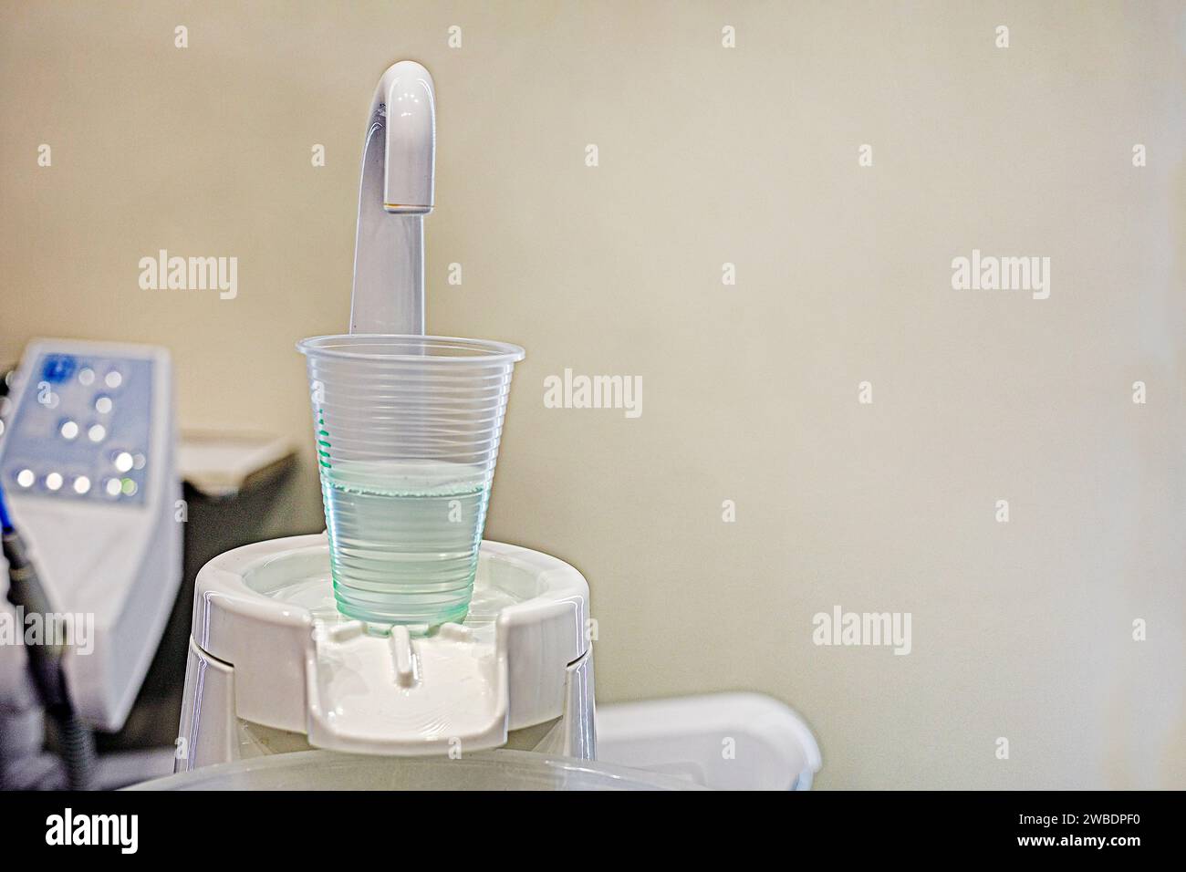 disposable cup with liquid for rinsing teeth in a dental office on a ...