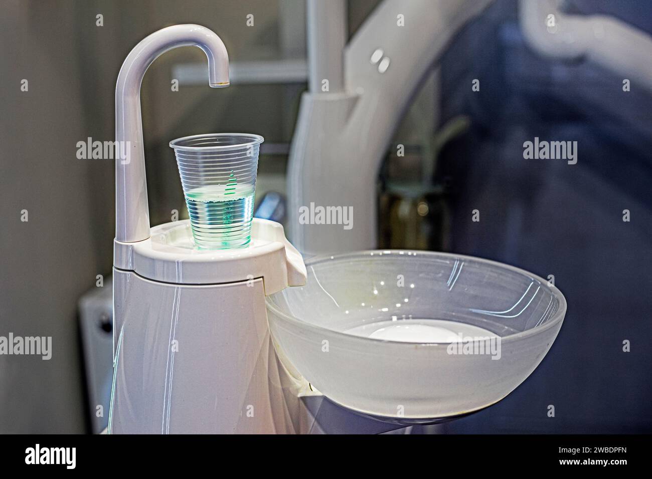 glass of liquid used for rinsing teeth in a dental office, emphasizing ...