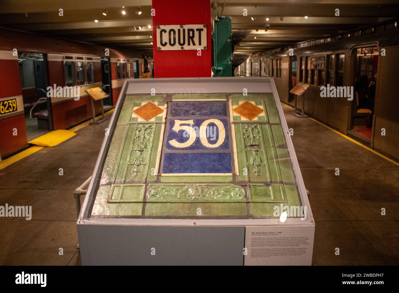 A vibrant sign with the number 50 next to a train at the Transit Museum ...