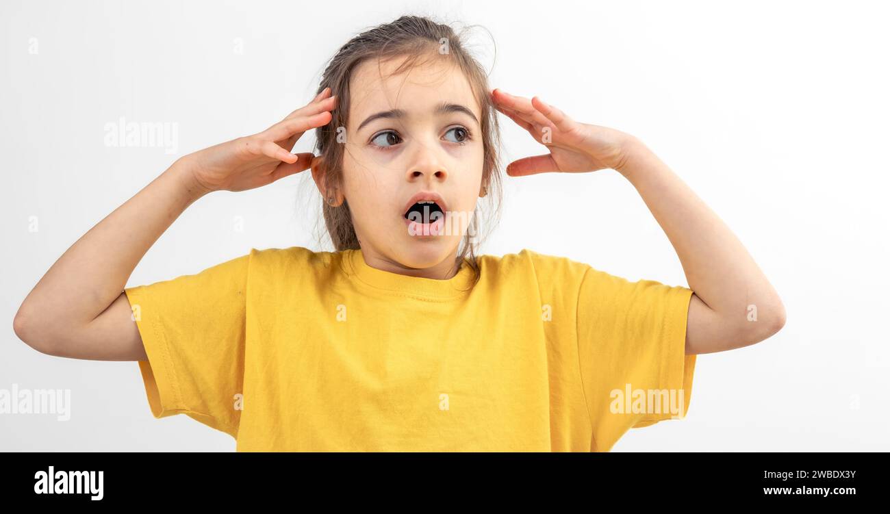 Little desperate girl looking panic, holding her head with both hands ...