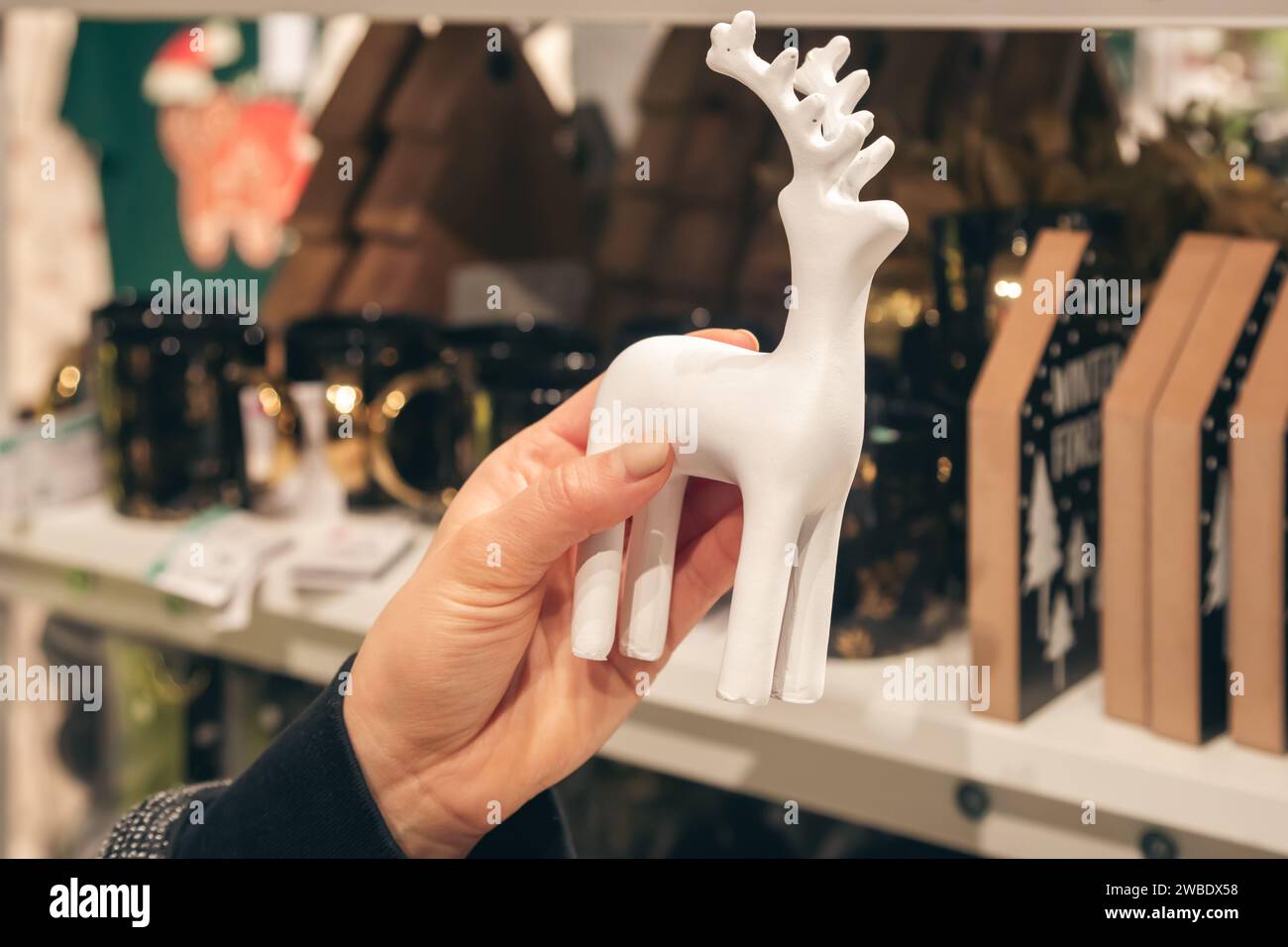 Decorative statue of a deer in female hands in a store Stock Photo - Alamy