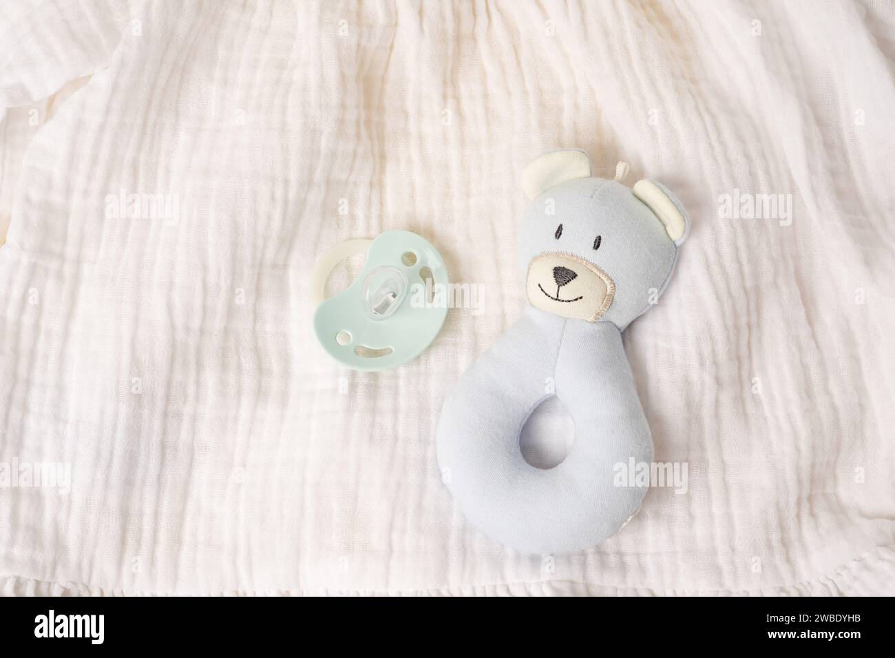 Blue toy bear and baby pacifier on white textile background Stock Photo ...
