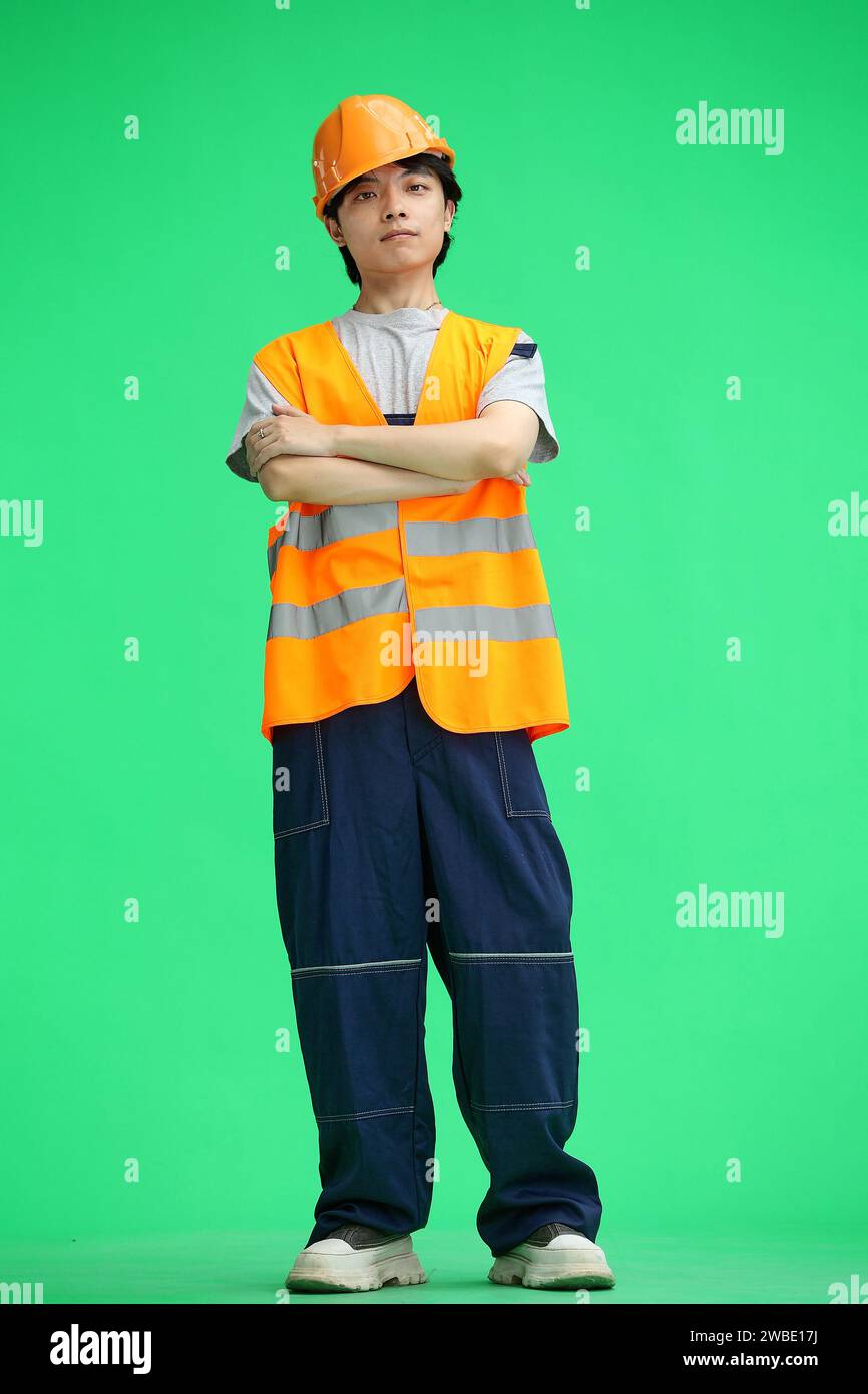 The construction guy, on a green background, in full height, crossed ...