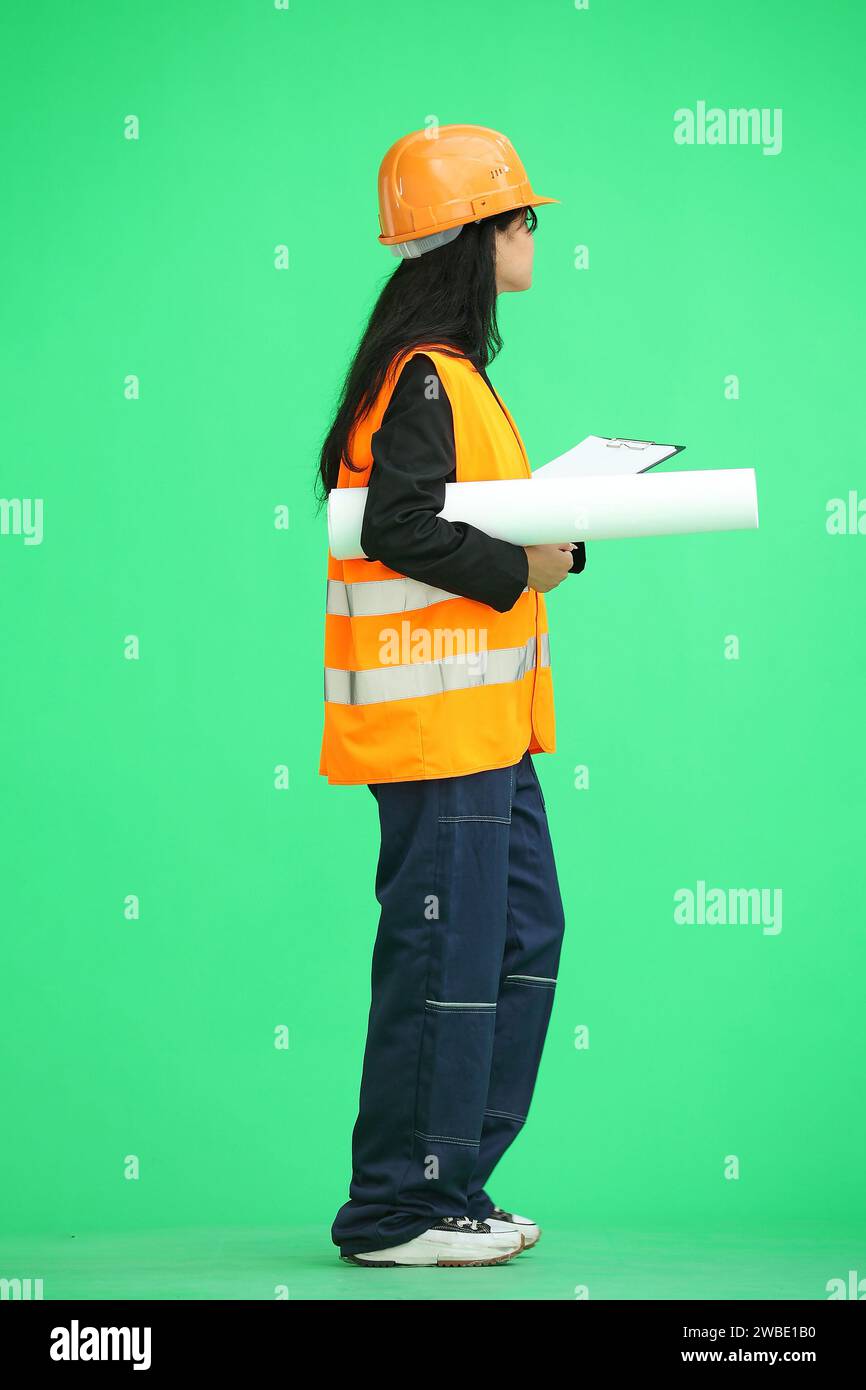 Construction girl on a green background, full-length, with drawings ...