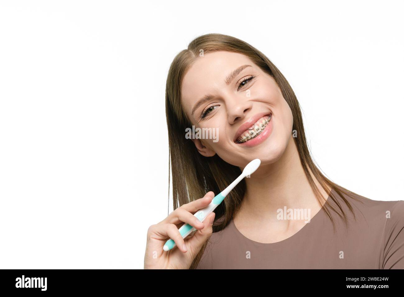 The girl smiles widely, holding a toothbrush in her hands and showing ...
