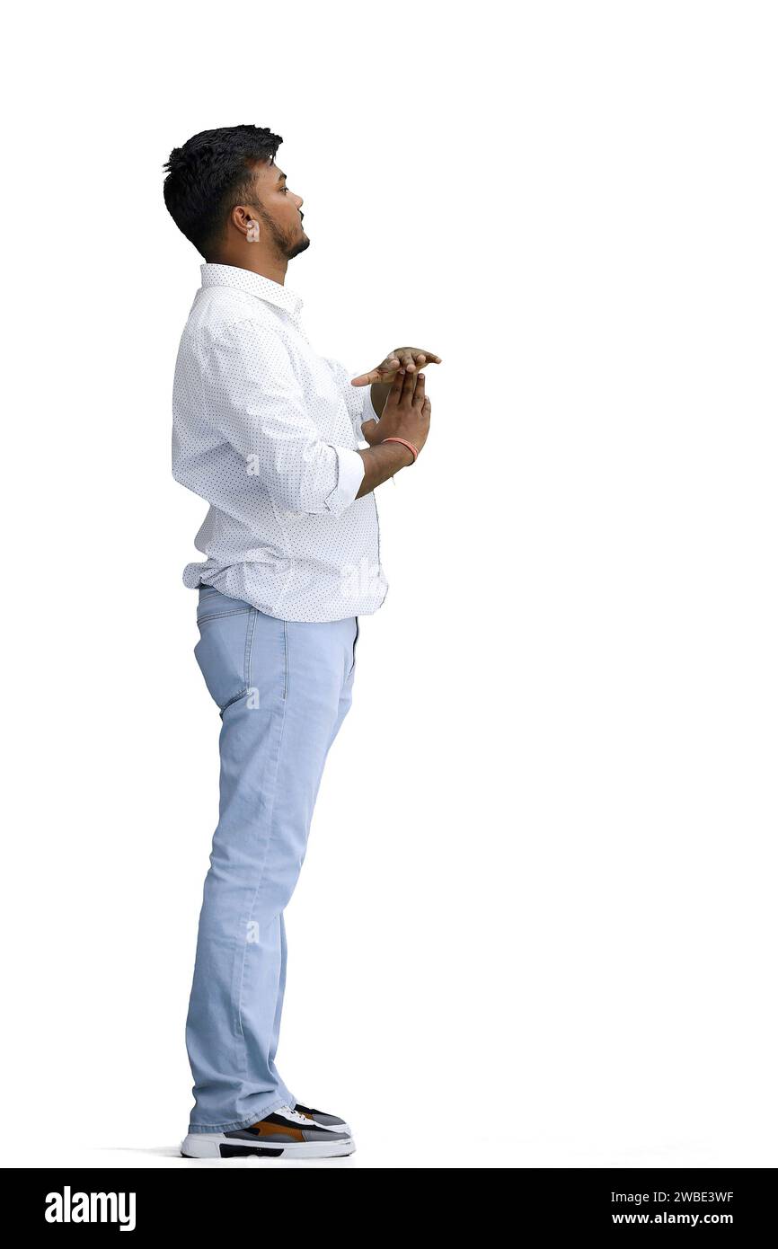 A man in a white shirt, on a white background, in full height, shows a ...