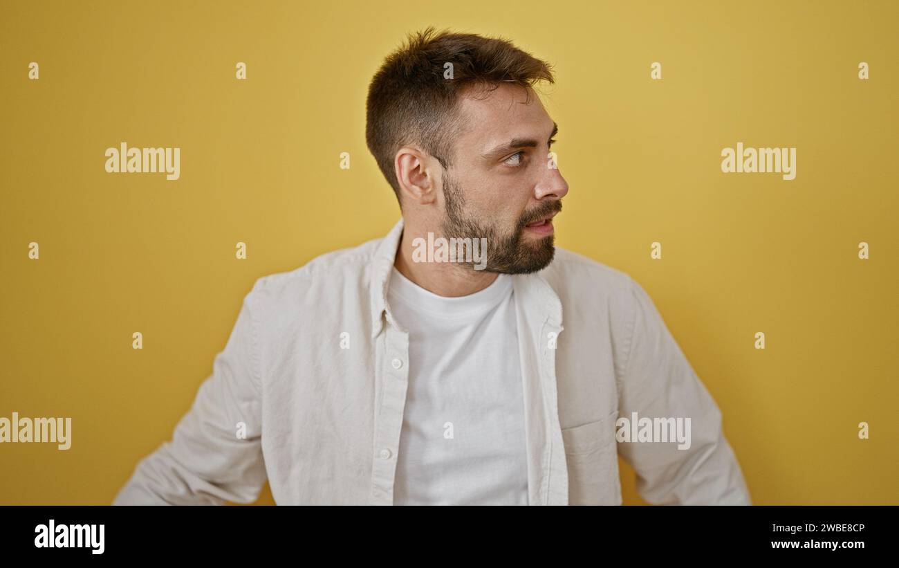 Chill yet serious, young hispanic guy with a beard giving a side glance ...