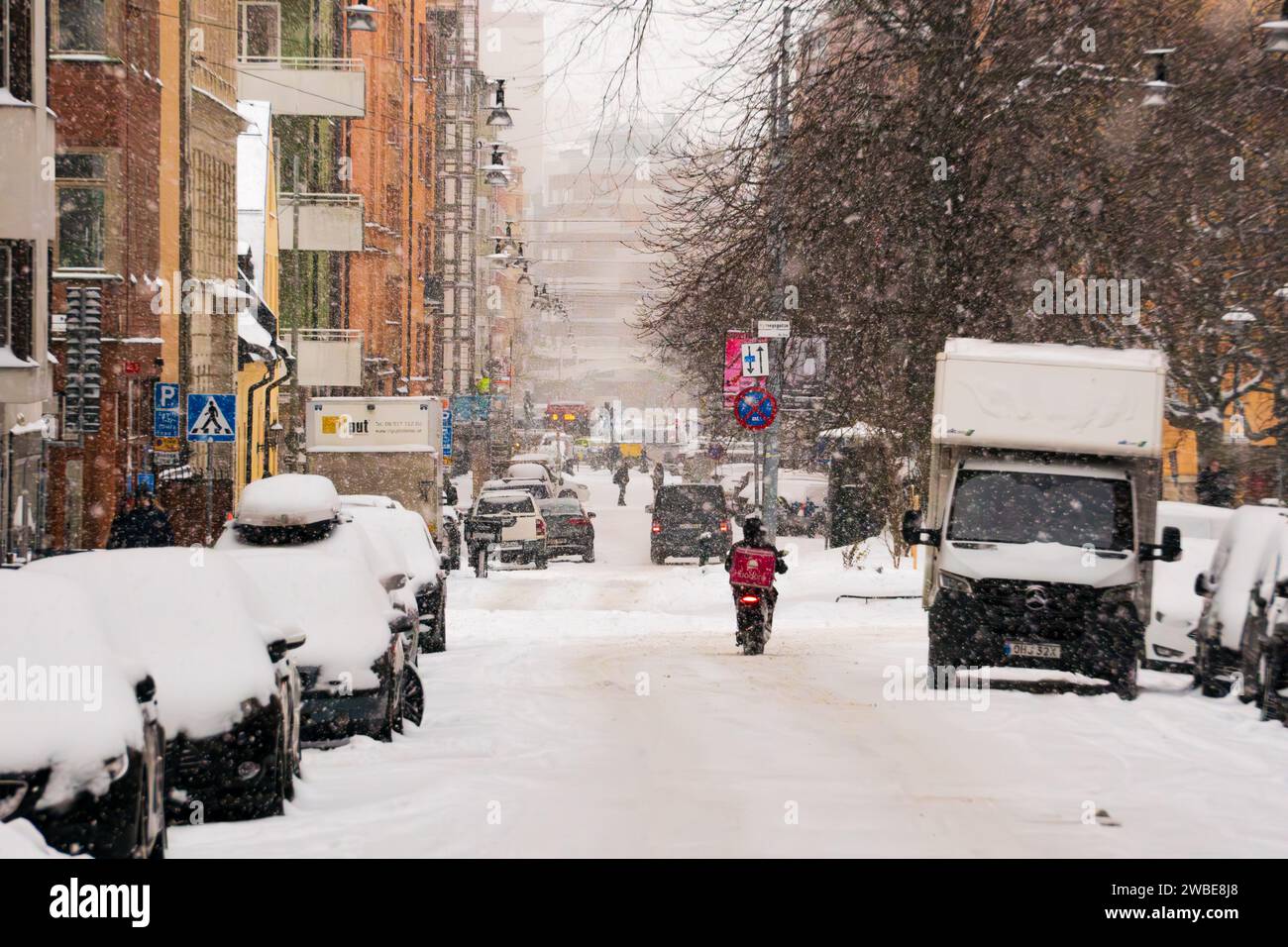 A person working for a food delivery company braving the snowstorm on a ...