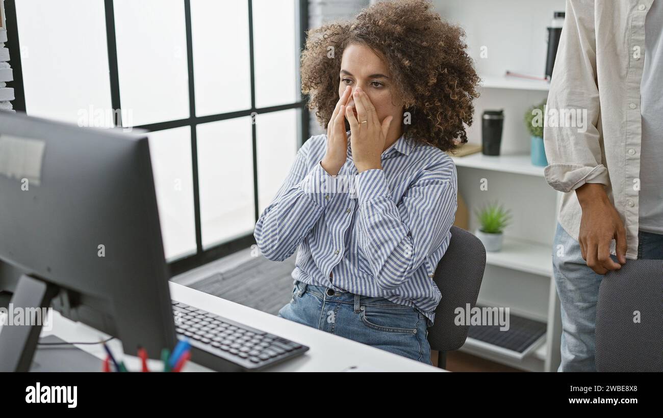 Two professional co-workers, man and woman, at the office, deep in ...