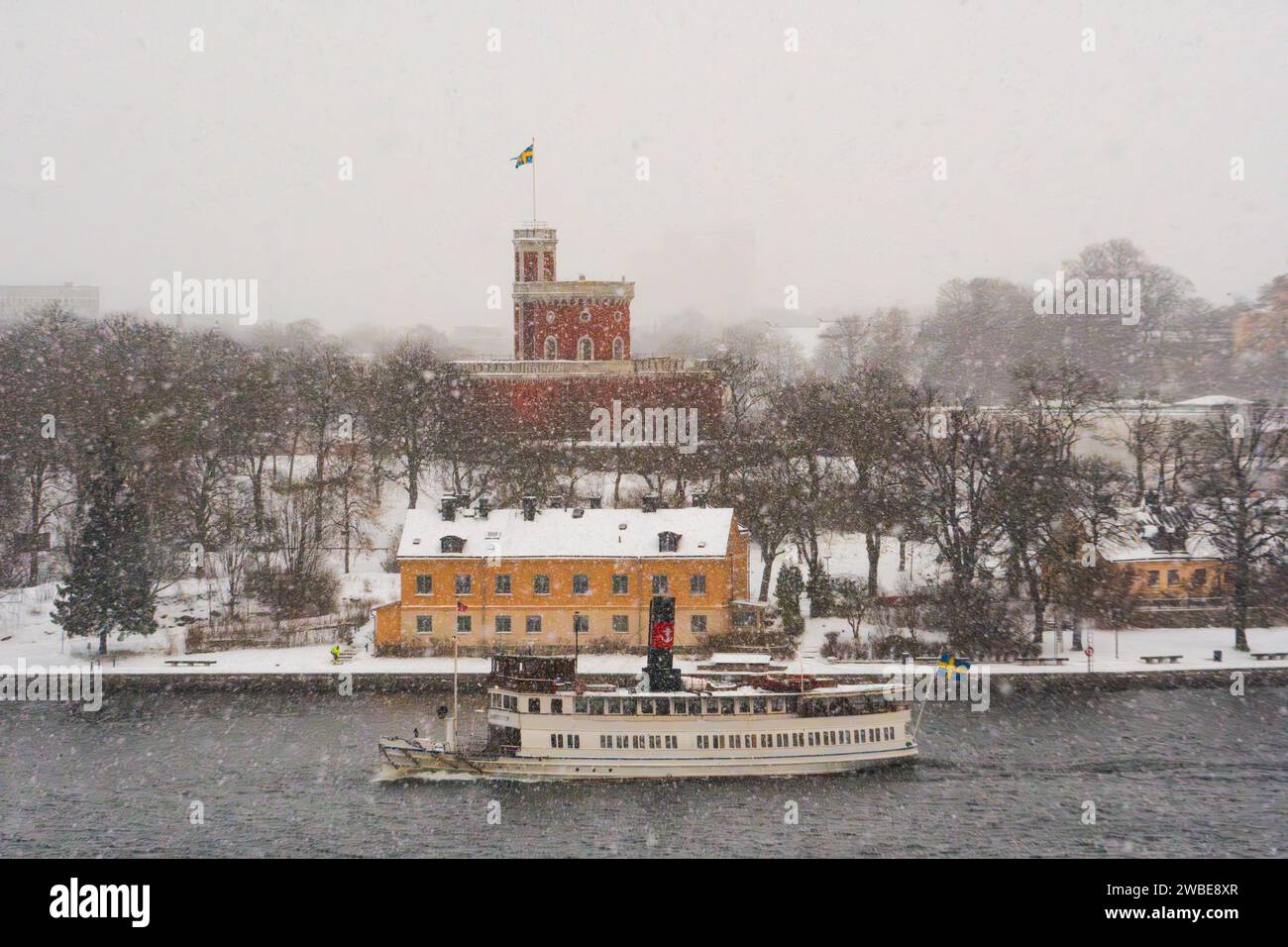 A snowstorm in Stockholm, Sweden. The castle of Kastellet in red on ...